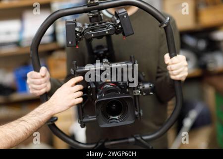 Professional videographer holding camera on 3-axis gimbal which mounted ...