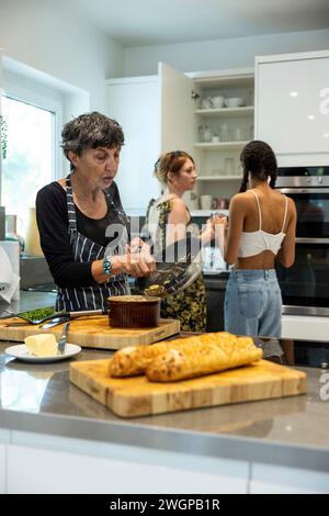 Group of friends standing in kitchen Stock Photo - Alamy
