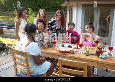 A mixed gathering of women laughing and having fun at a summer garden ...