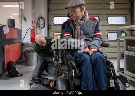Mechanic working on mans prototype wheelchair Stock Photo - Alamy