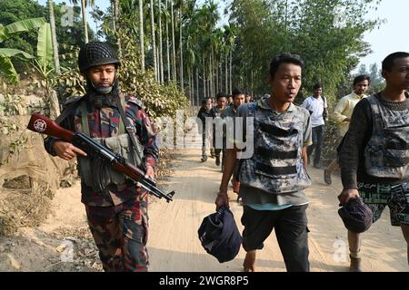 Members of Myanmar Border Guard Police, in civilian clothing, sit under ...