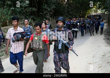 Members of Myanmar Border Guard Police, in civilian clothing, sit under ...
