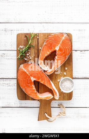 Fresh raw salmon steaks on white concrete table. Top view of fish on ...