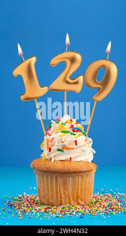 Candle number 129 - Cupcake birthday in blue background Stock Photo - Alamy