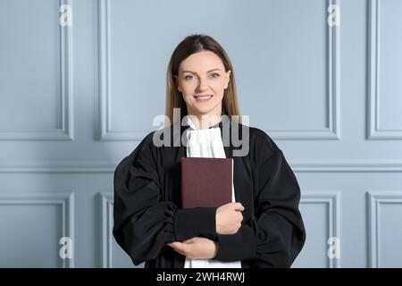 Portrait of judge with book near grey wall Stock Photo - Alamy