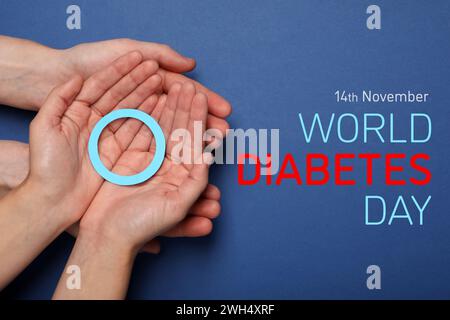 World Diabetes Day. People holding light blue ribbon with paper blood ...