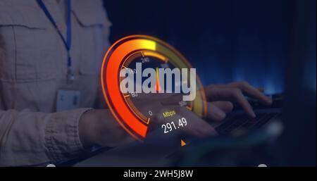 Image of orange speedometer over hands of biracial man using laptop ...
