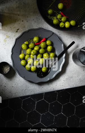 Fresh olives with chili pepper and thyme in bowl on rustic wooden ...