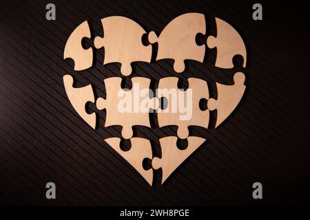 Heart shape from cardboard puzzles. Heart made from puzzles on wooden ...