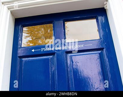 Dark blue glossy painted door has a direction arrow and the instruction ...