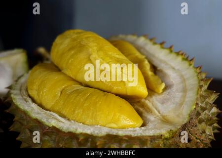 A close up photo of a Musang King durian, a spiky, oval-shaped fruit ...