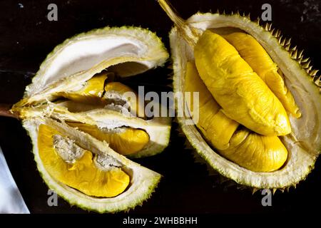 A close up photo of a Musang King durian, a spiky, oval-shaped fruit ...