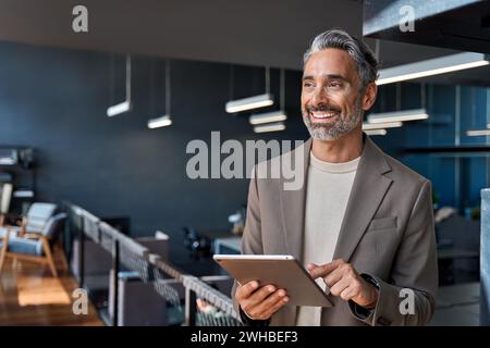 Happy mature business man ceo executive standing in office with tablet ...