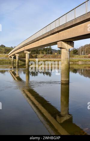 A bridge over a river with its image reflecting in the water, in a ...