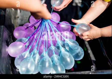 Rapid filling self sealing water balloons being inflated with a hose ...
