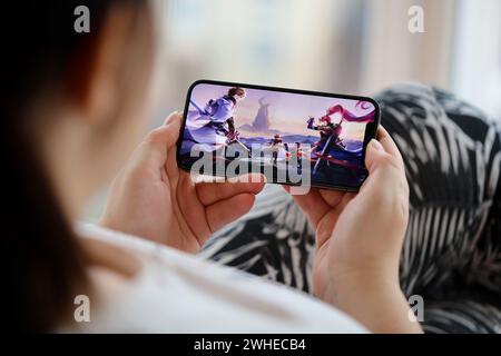 Honor of Kings mobile iOS game on iPhone 15 smartphone screen in male ...