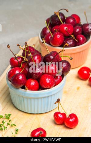 Red ripe cherries in ceramic bowls on kitchen countertop. Slide from ...