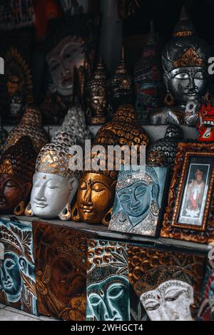 Handmade gold plated Buddha face masks on a counter in a street shop on ...