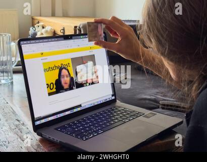 Woman is identifying herself in a PostIdent procedure on a laptop in ...