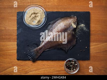 Fresh uncooked flounder fish with spices on wooden board Stock Photo ...