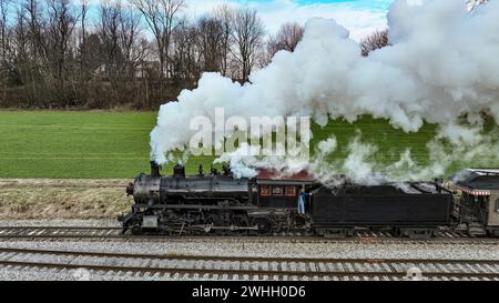 Side Drone View of a Steam Locomotive Approaching Traveling Thru Fields ...