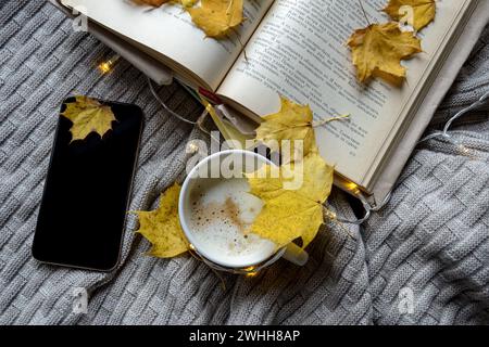 Smartphone on maple leaves background with some coins. Autumn ...