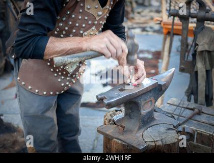 Metal craftsman in foreground with medieval background Stock Photo - Alamy