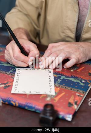 Man writing with quill on parchment paper Stock Photo - Alamy
