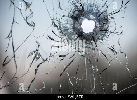 Bullet hole in cracked window glass Stock Photo - Alamy
