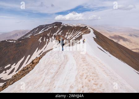 mountaineers on the ridge reaching the top Ighil M'Goun, 4,071 meters ...