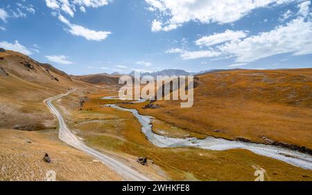 River Kol Suu winds through a mountain valley with hills of yellow ...