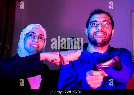 arabic muslim sibling playing together console games Stock Photo - Alamy