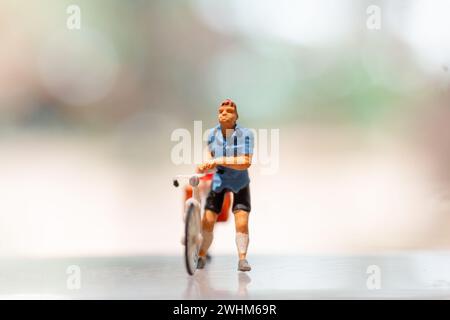 Miniature cyclist standing with bike, World bicycle day concept Stock ...