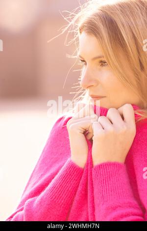 Young woman in cozy sweater using mobile smartphone in room with ...
