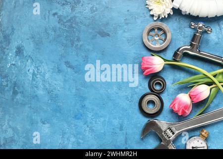 Composition with plumber's items and tulip flowers on color background ...