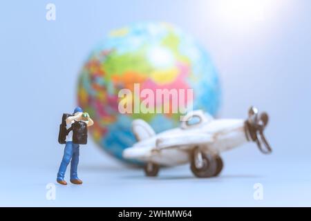 Miniature peopleT ravelers with airplane and globe Stock Photo - Alamy
