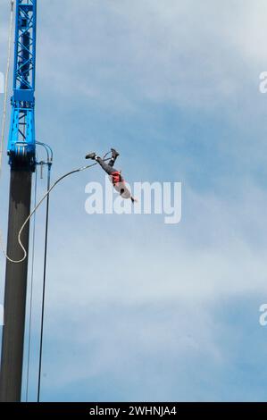 Bungee jumping from a great height while connected to a large elastic ...