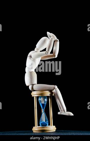 Wooden dummy and hourglass sandglass vintage clock, time concept ...