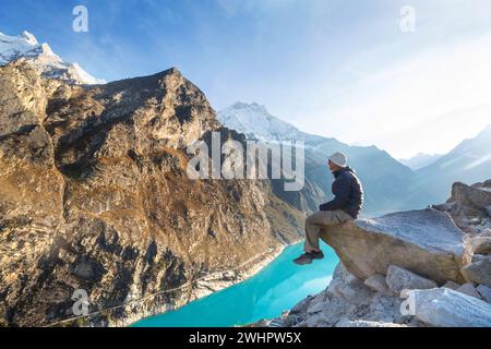 Hiker admires the lake Paron in Cordillera Blanca, Peru, South America ...