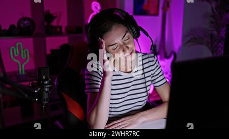 Young beautiful hispanic woman streamer wearing headset smiling at ...