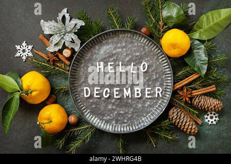 Hello December text. Winter composition with fir branches, cones and ...