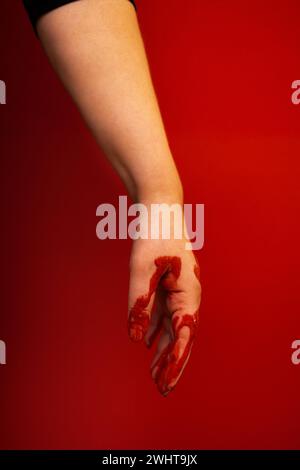 The bloodied hand of a caucasian girl. Red blood trickles from the ...