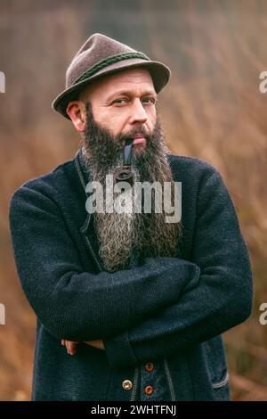 Portrait of a typical bavarian man smoking a pipe and wearing a ...