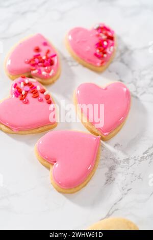 Flat lay. Decorating sugar cookies shaped as figure skates with royal ...