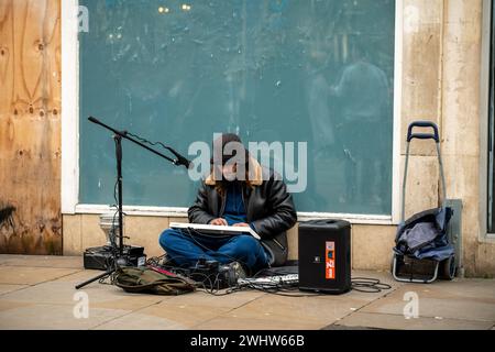 Homeless man plays on keyboard outside shops Stock Photo - Alamy
