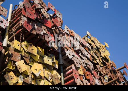 Pile of assorted colored steel jack posts with base plates in outdoor ...