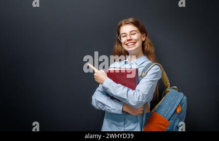 Back to school! Happy cute industrious child is sitting at a desk ...