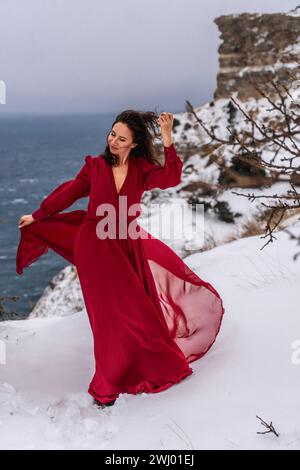 Woman red dress snow sea. Happy woman in a red dress in the snowy ...