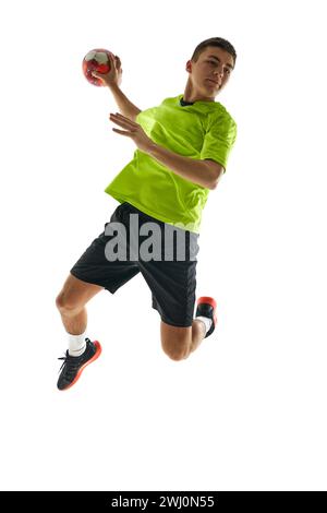 Young guy in uniform, handball player in a jump, throwing ball during ...