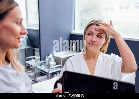 Doctor checking woman face skin in cosmetology clinic before plastic ...